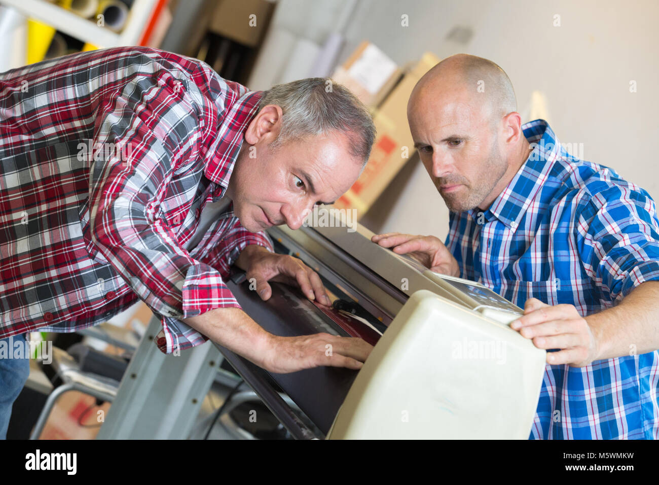 Men repairing industrial equipment Stock Photo - Alamy