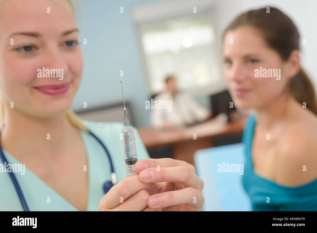 Nurse preparing syringe for female patient Stock Photo - Alamy