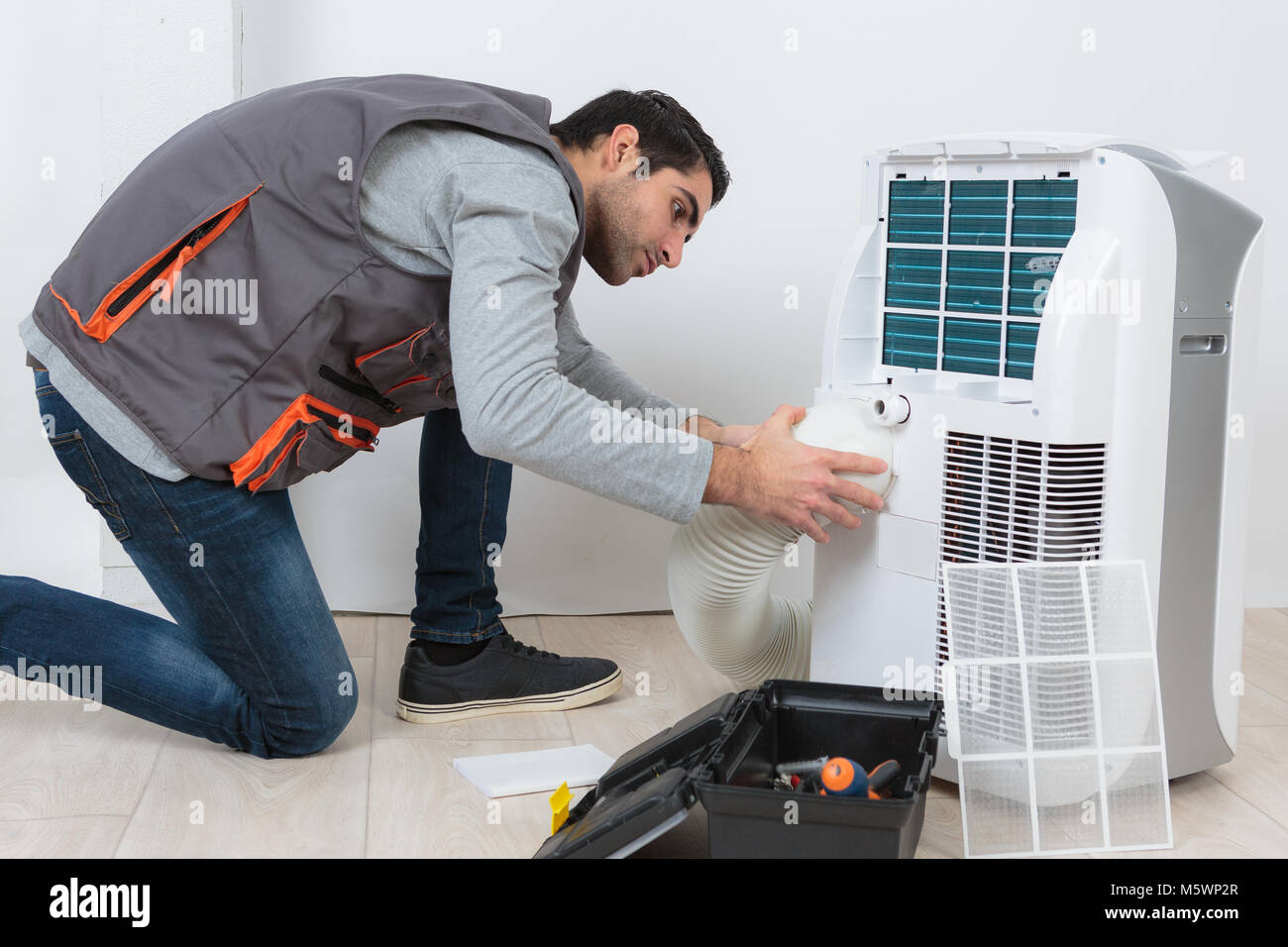 Man working on air conditioning unit Stock Photo - Alamy