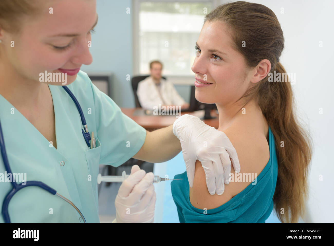 happy doctor giving an injection to female patient at office Stock ...