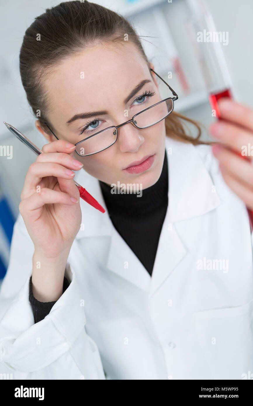 seriously looking female doctor with blood probe and request form Stock ...