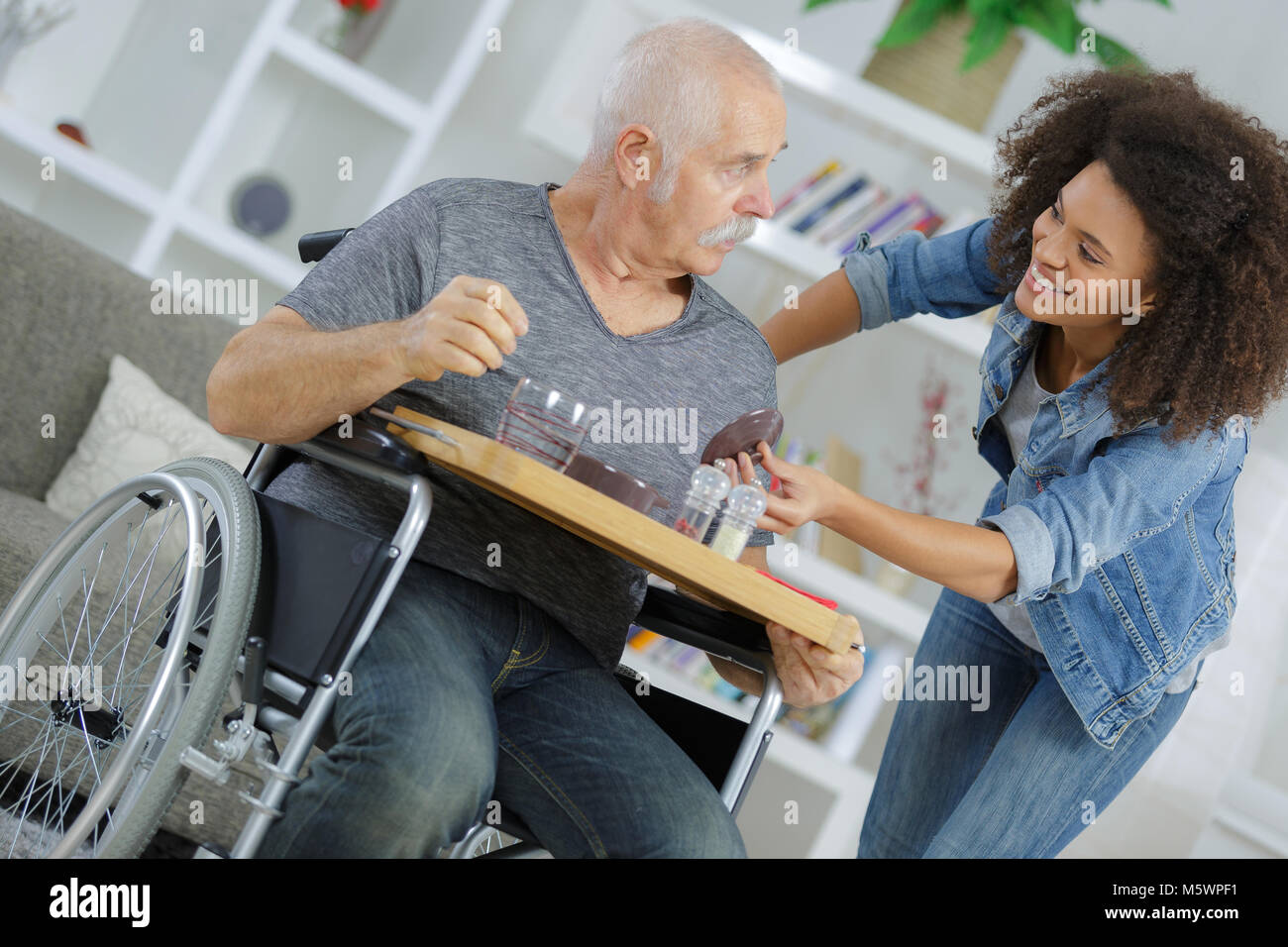 female assisting an old man Stock Photo - Alamy