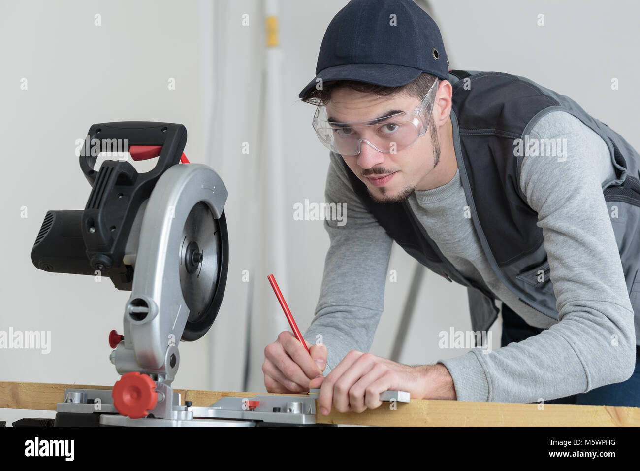 young carpenter using circular saw for wood Stock Photo - Alamy
