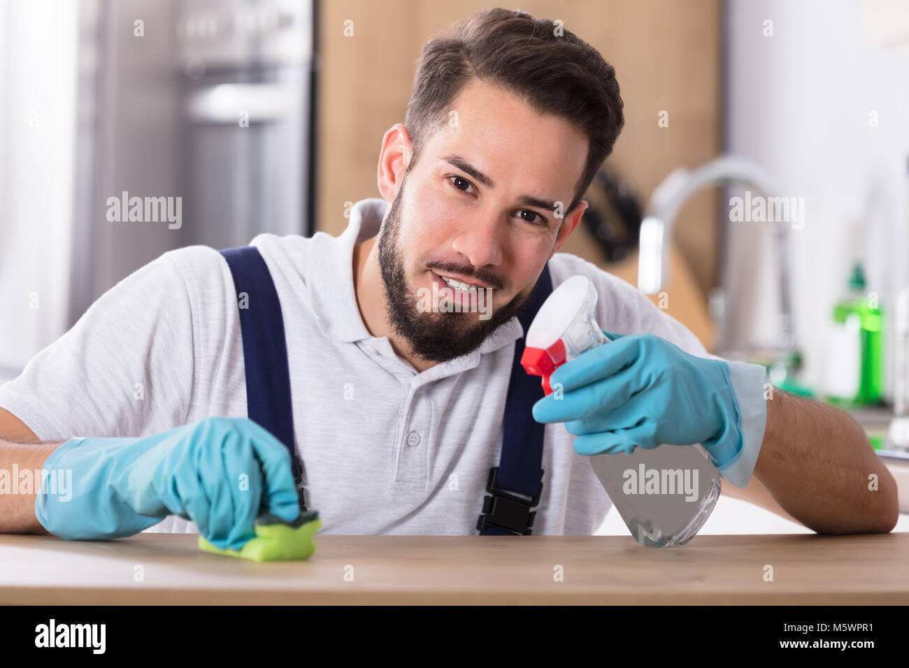 Portrait Of A Happy Young Man Cleaning Kitchen Worktop Stock Photo - Alamy