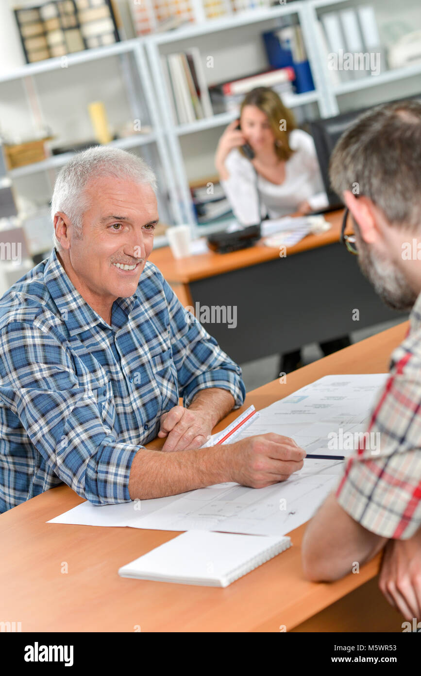 Happy architect sat with client Stock Photo - Alamy