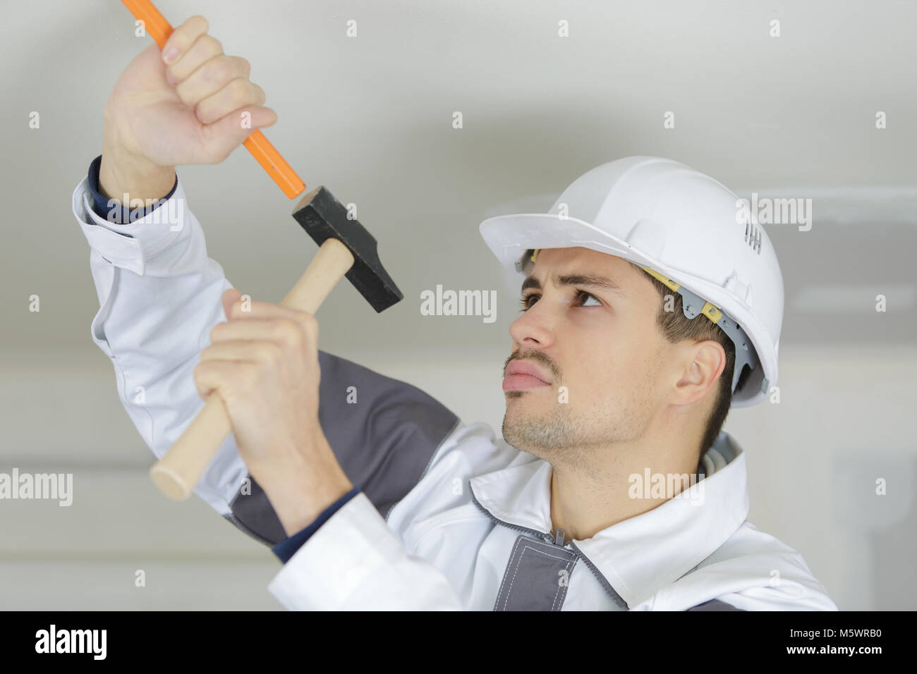 builder making a hole on the ceiling Stock Photo - Alamy