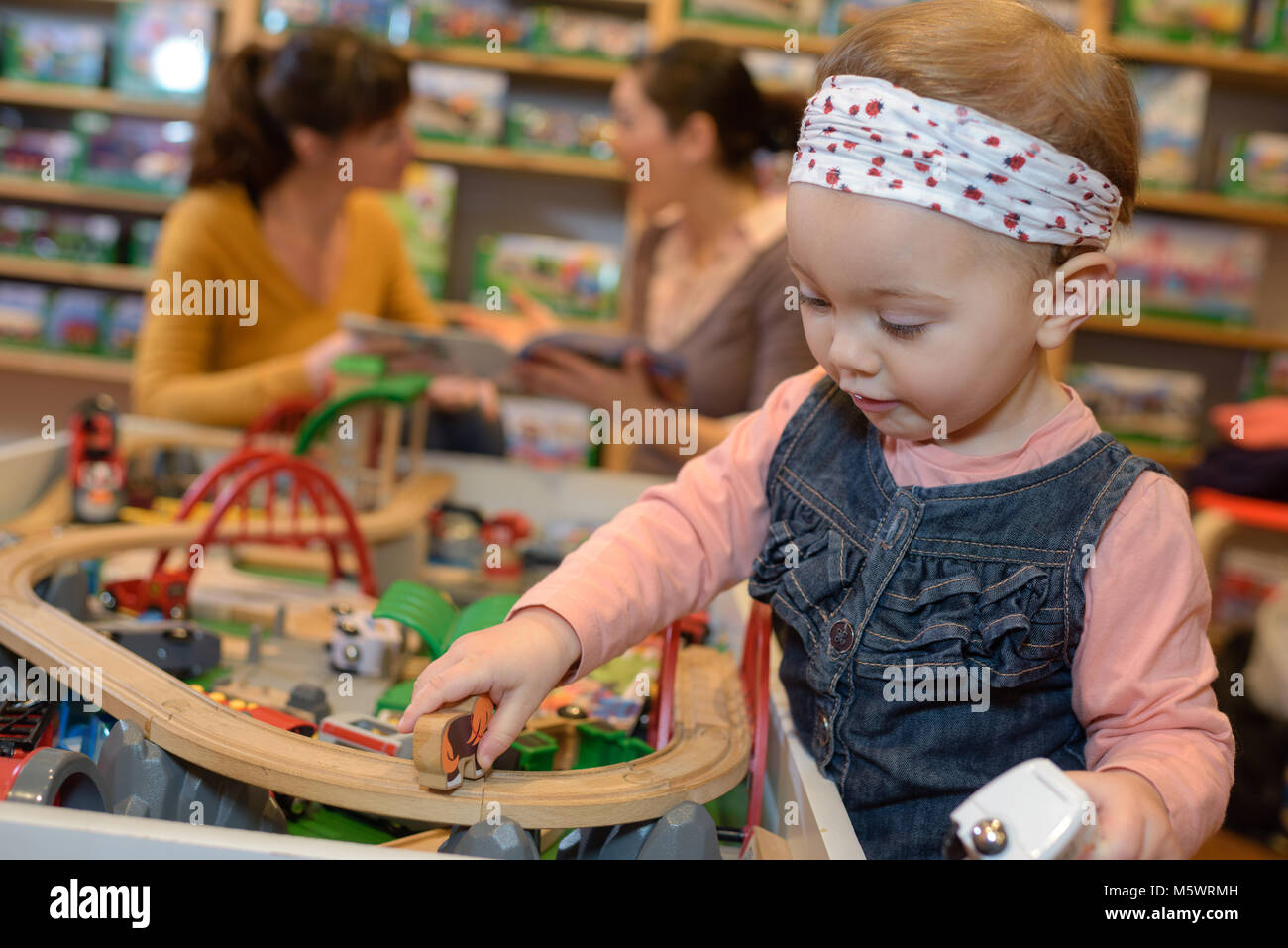 little girl having fun in a toy store Stock Photo - Alamy