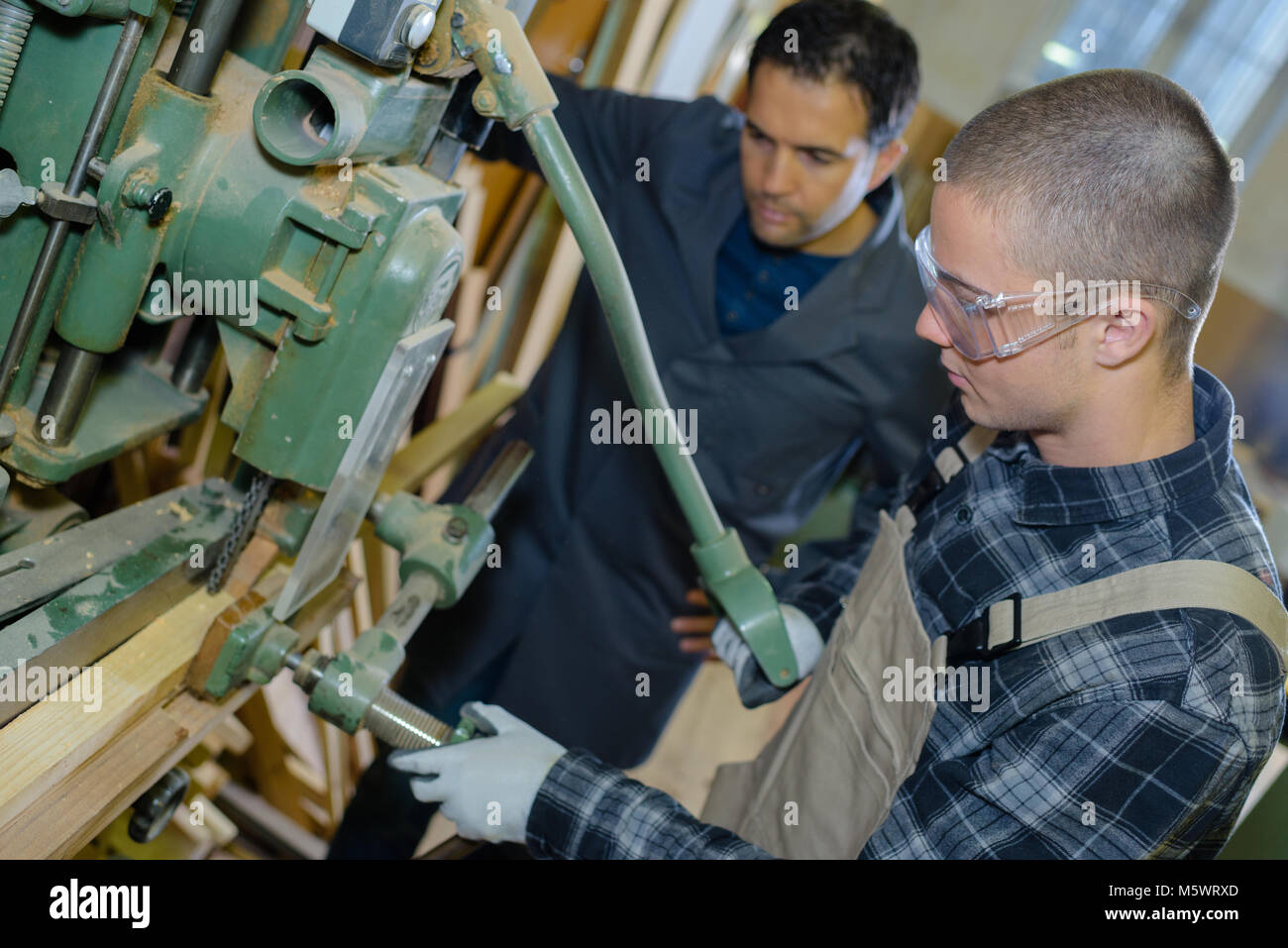 apprentice worker learning on factory machine Stock Photo - Alamy