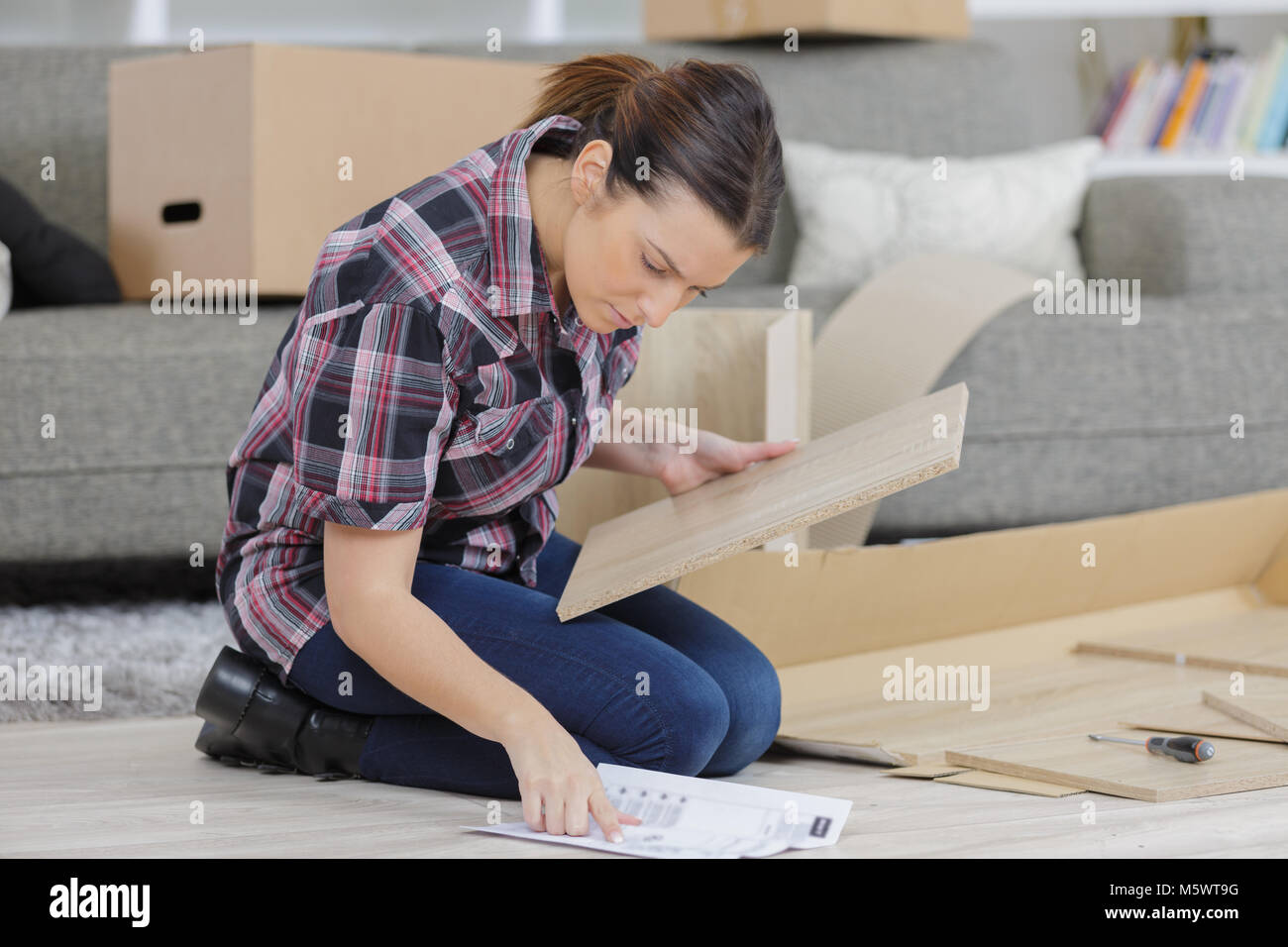 frustrated woman with self assembly furniture in kitchen Stock Photo ...