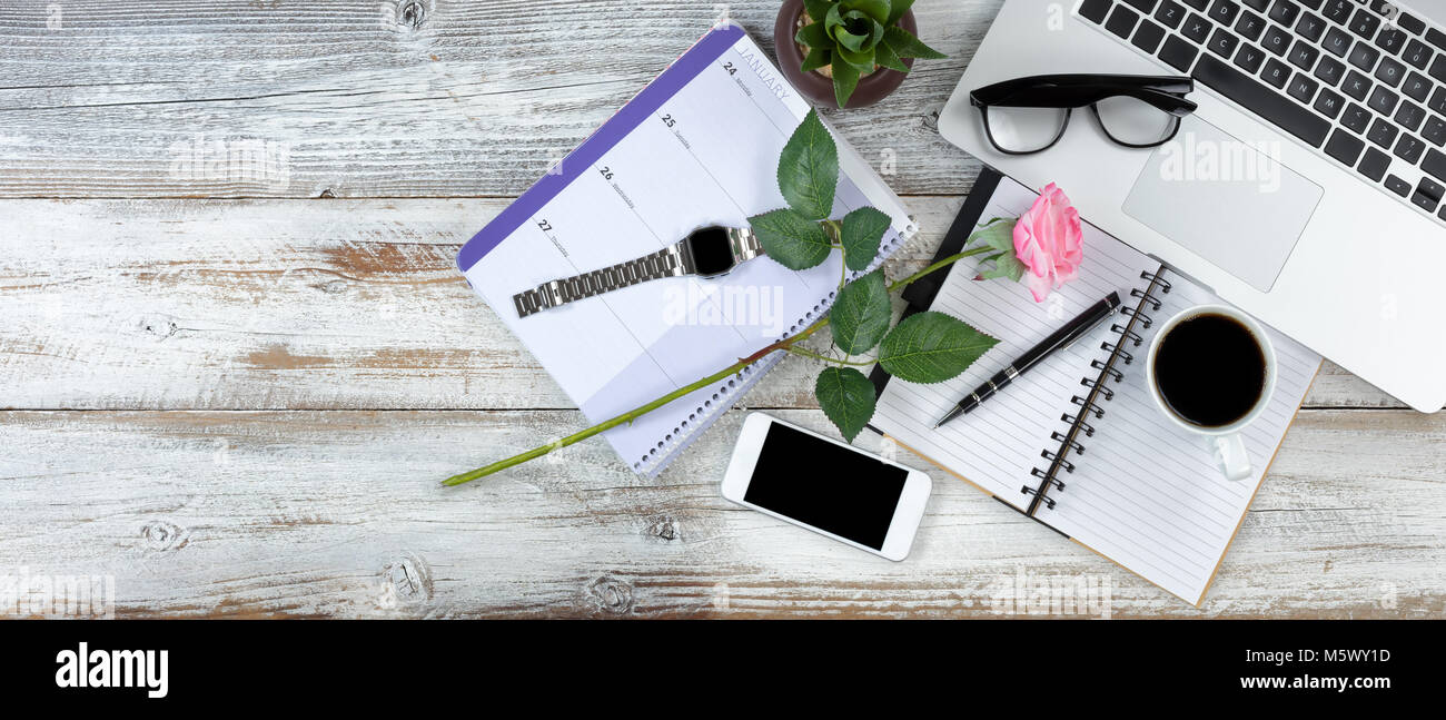 Office desktop with laptop, calendar, coffee and pink rose on white ...