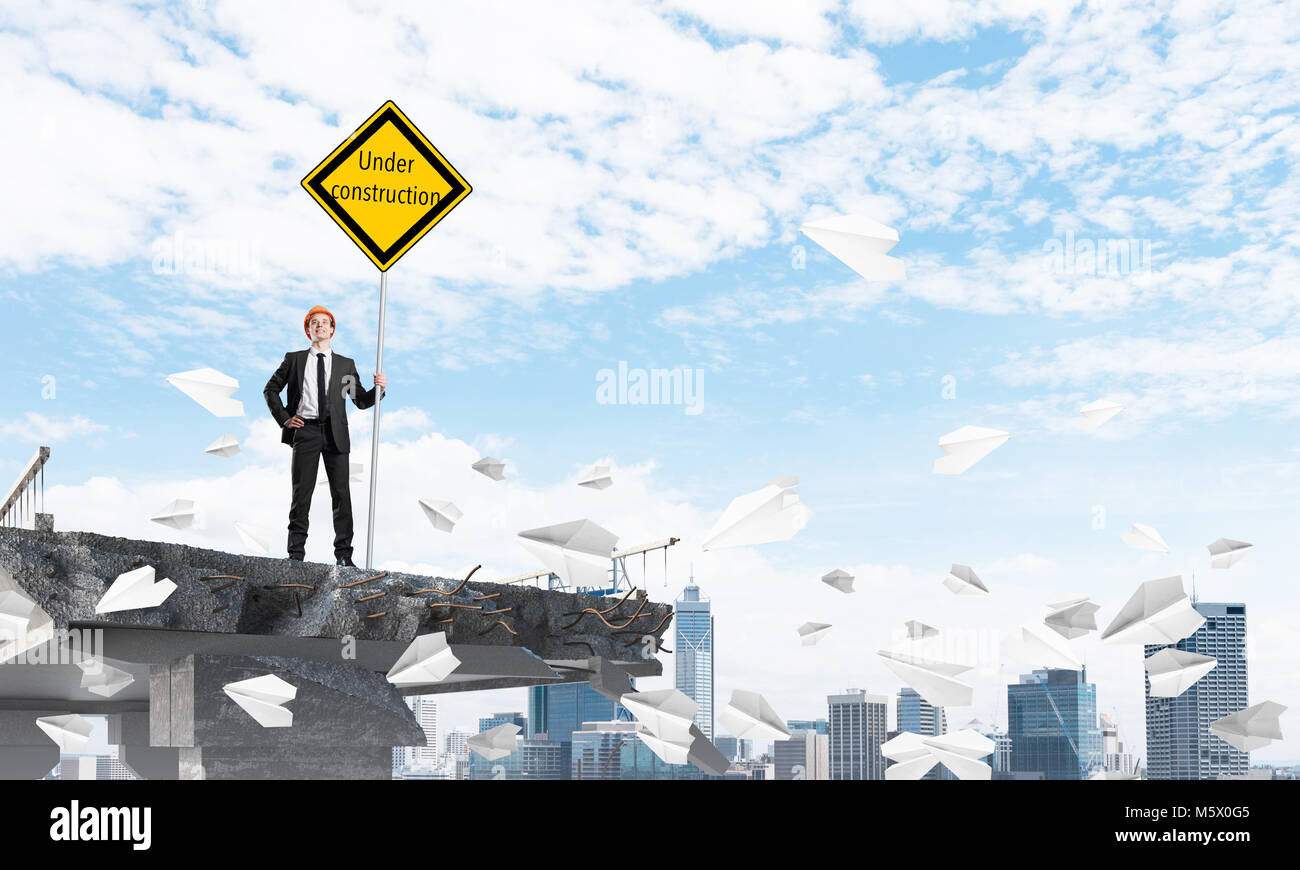 Confident engineer holding street safety sign Stock Photo - Alamy