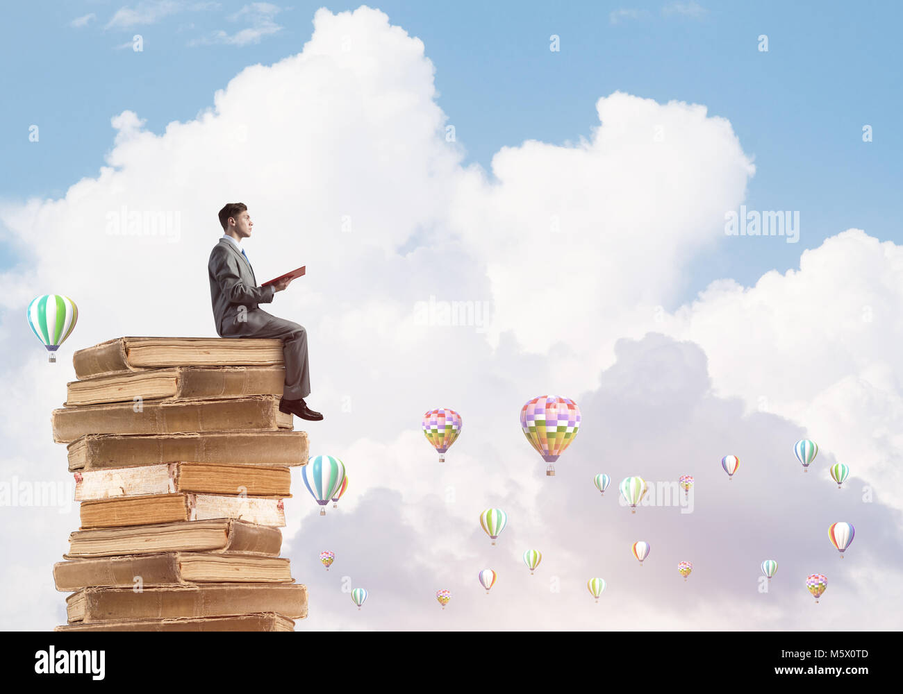 Man student reading book and aerostats flying around in air Stock Photo ...