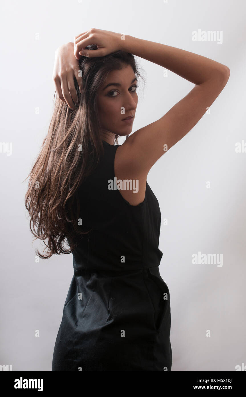 Beautiful young woman looking over shoulder hands touching head Stock ...