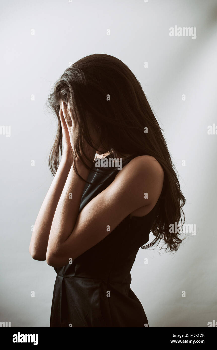 Side view of a sad young woman hiding face with hands crying Stock ...