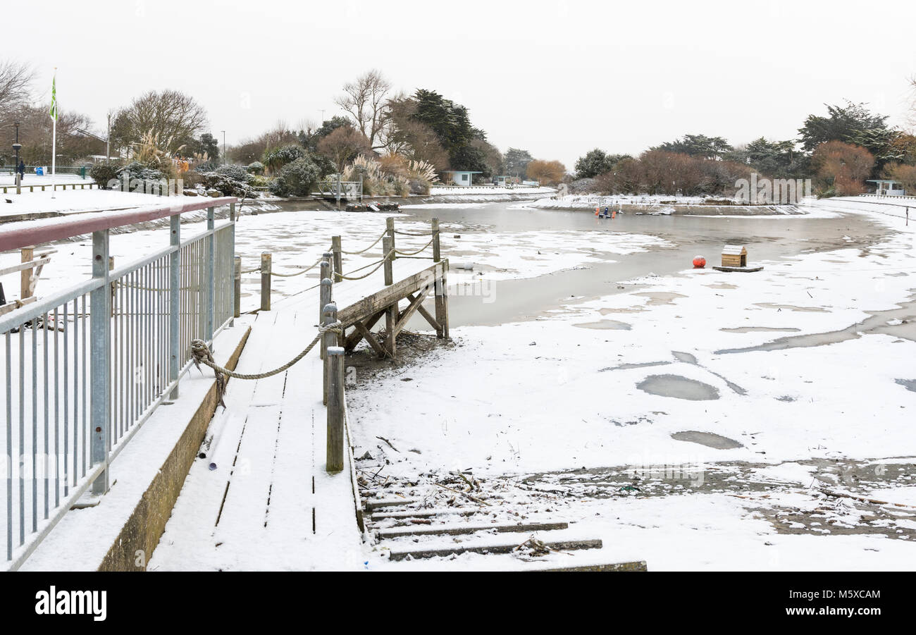 Snow and ice on a frozen boating lake in Winter in Mewsbrook Park ...