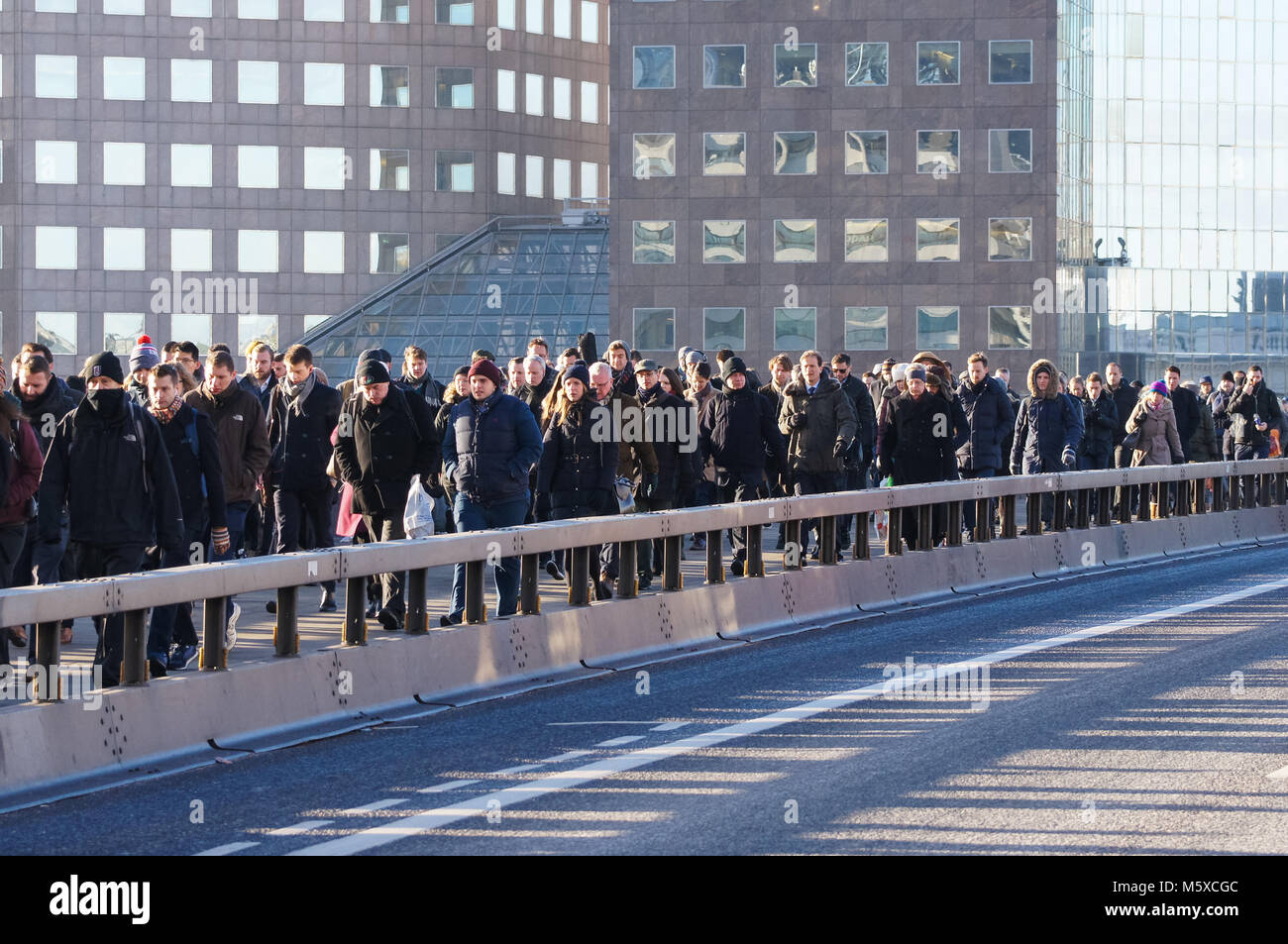 Office workers crossing London Bridge on a cold winter morning, London ...