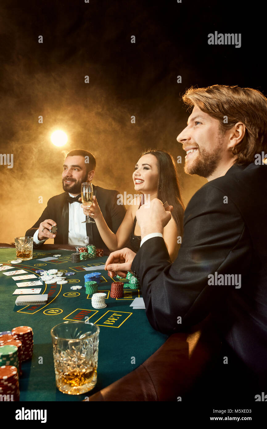 Group of young rich people is playing poker in the casino Stock Photo ...