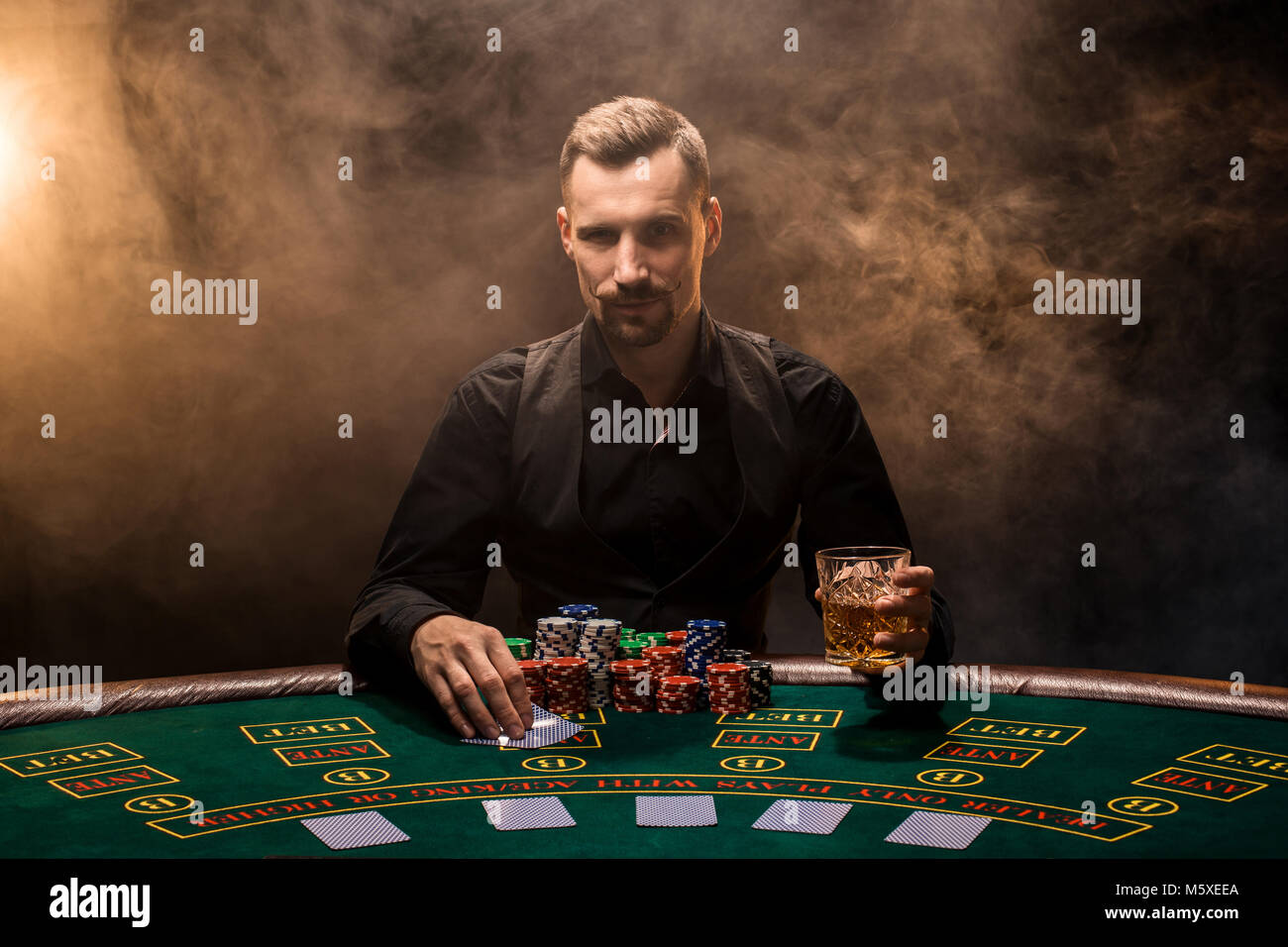 Poker player. Young guy in the casino at the gaming table. Man gambling ...