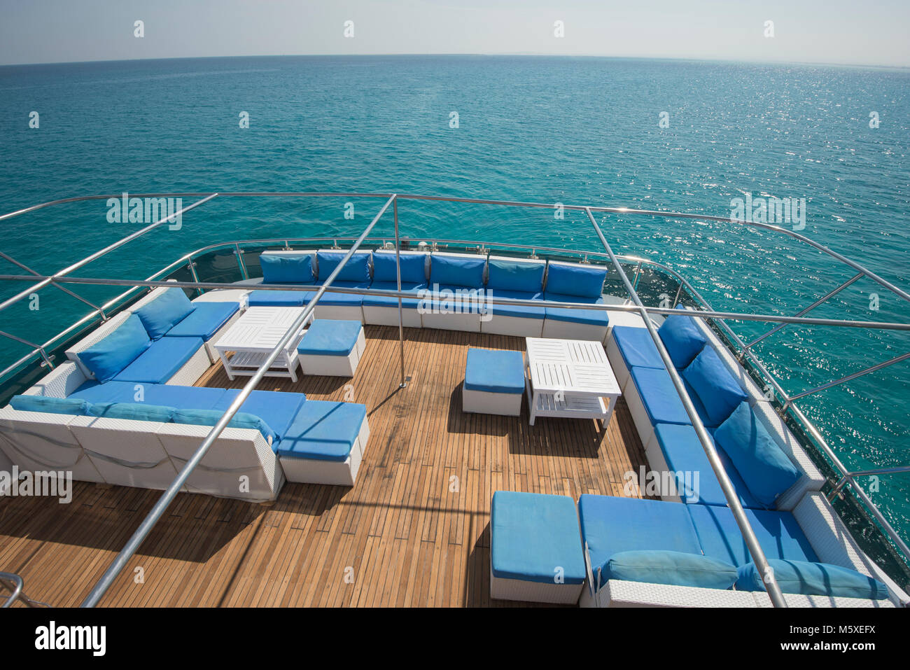 Rear teak deck of a large luxury motor yacht with chairs sofa table and ...