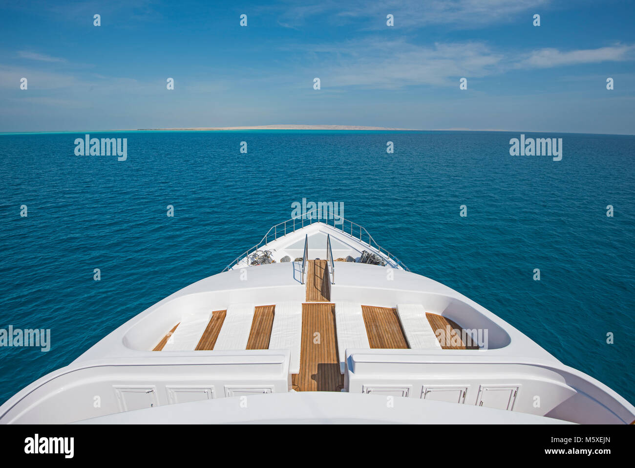 View over the bow of a large luxury motor yacht on tropical open ocean ...