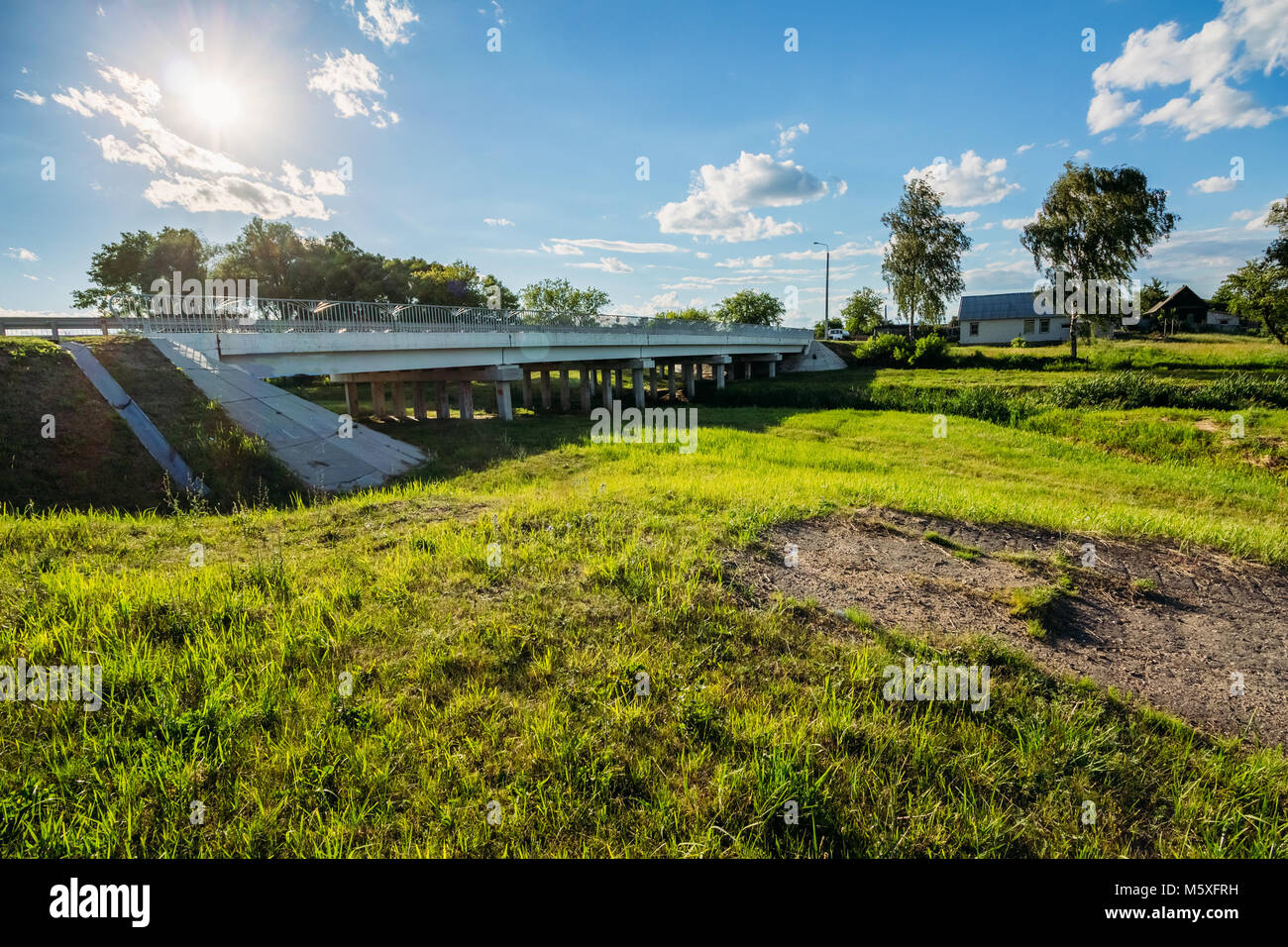 The road bridge in the town in the summer in a landscape on a ...