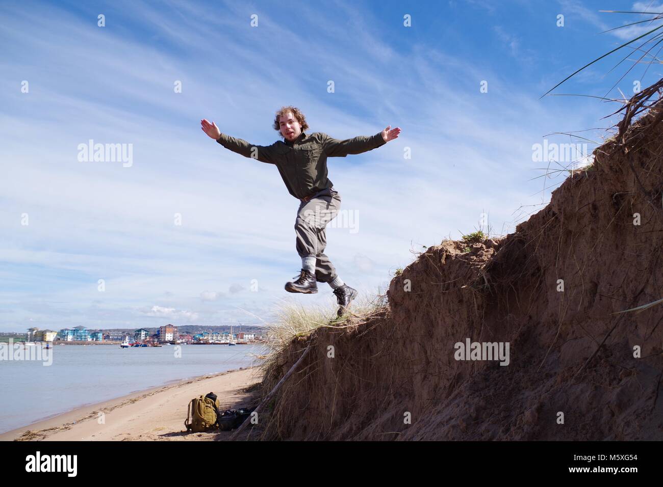Ruggedly Handsome British Explorer, Dressed in Green Leaping from Sand ...
