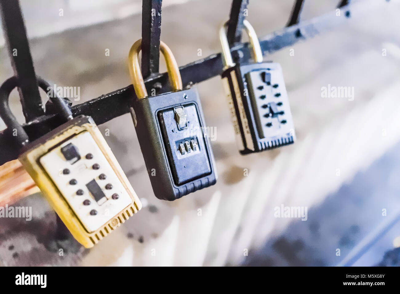 Closeup of three hanging locks safe for keys portable boxes on railing ...