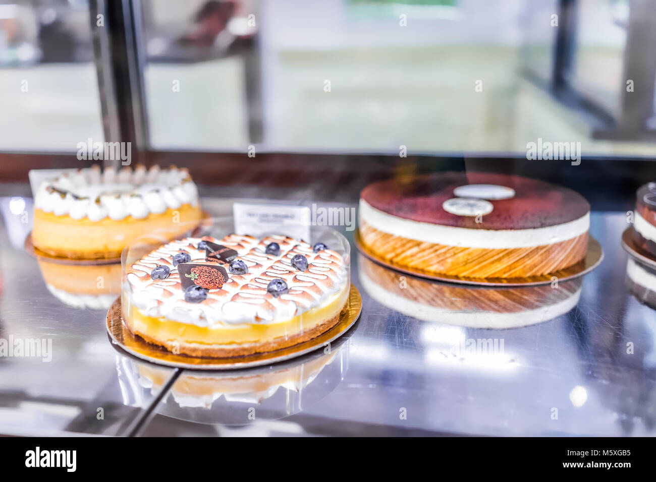 Many cakes on display in bakery shop store with tiramisu, cream ...