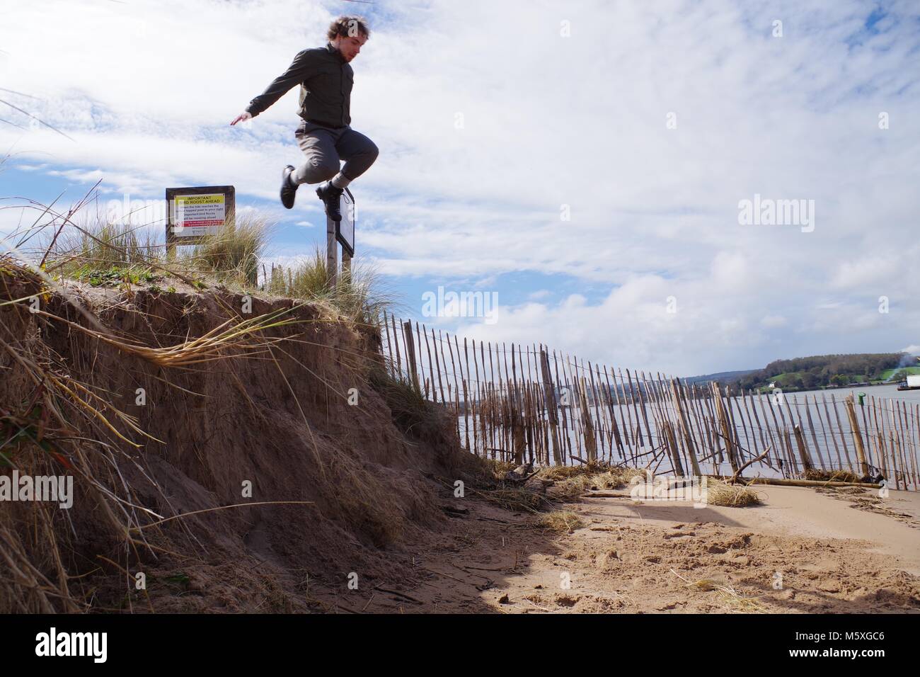 Ruggedly Handsome British Explorer, Dressed in Green Leaping from Sand ...