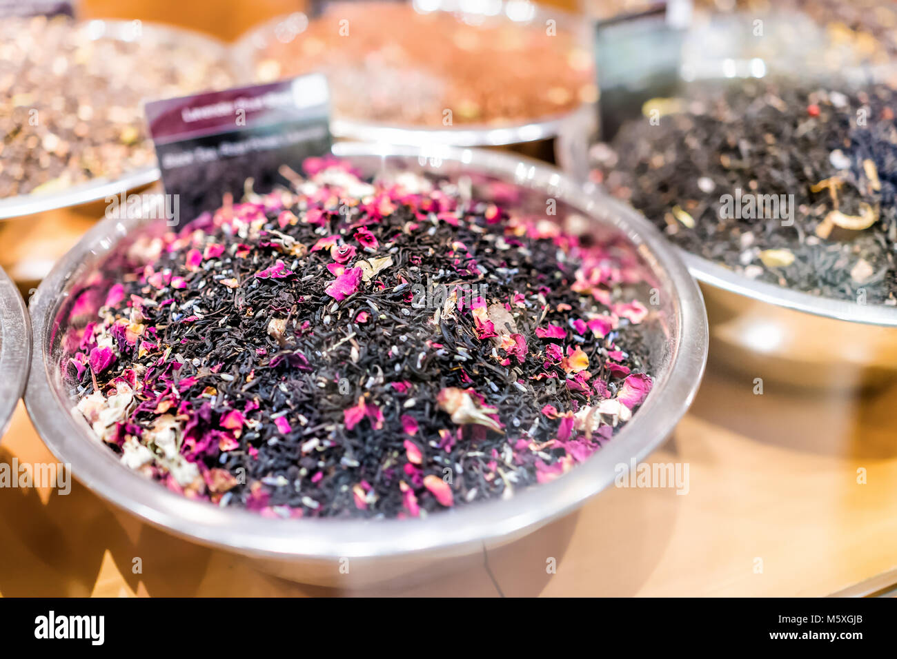 Closeup of black rose tea spices on display in metal bowl tray filled ...