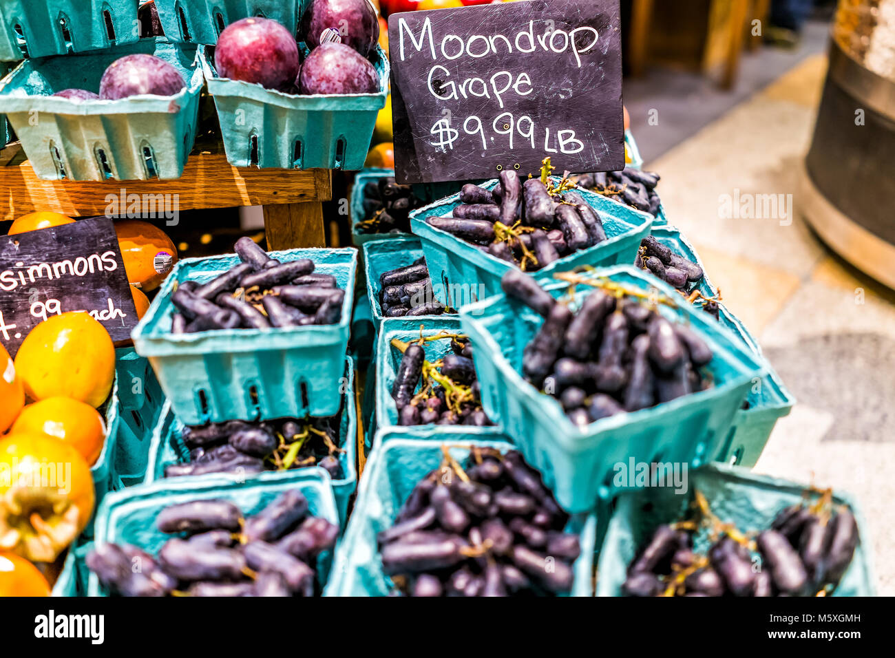Closeup of many fresh purple juicy moon drop moondrop grapes in boxes ...