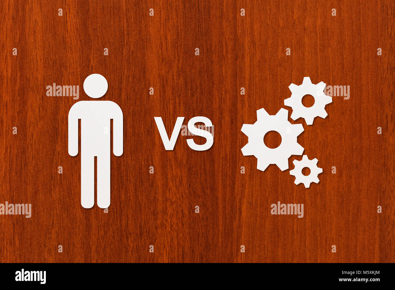 Paper man vs technology, cogwheels, mechanism. Wooden background ...