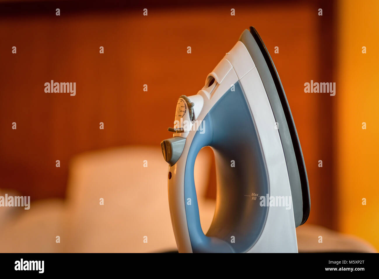 closeup of a household hand iron resting in upright position in home ...
