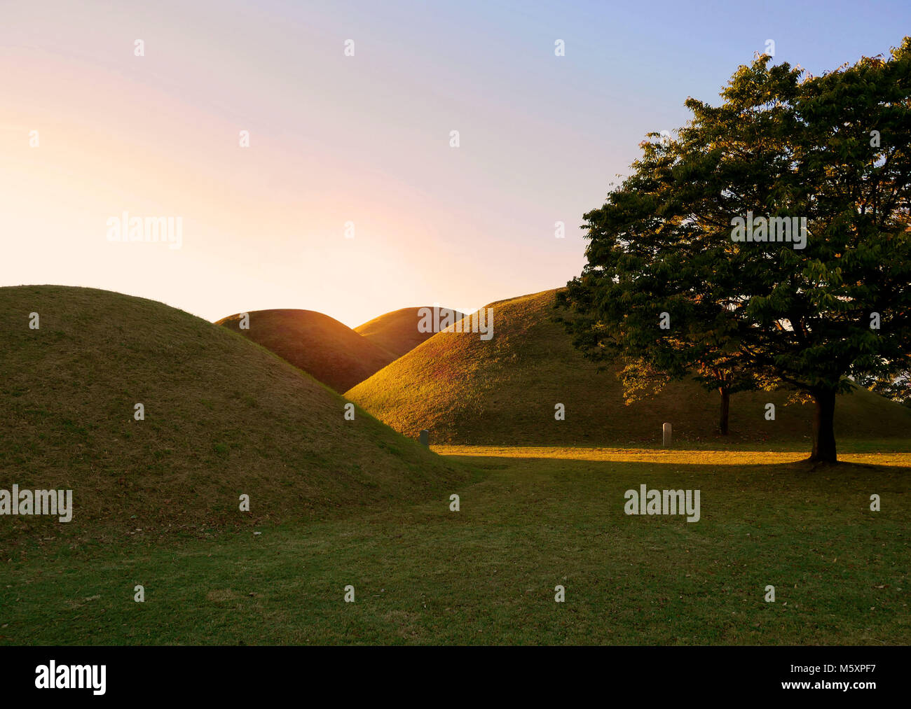 The sun rise over the Tumuli park royal tombs complex located in ...