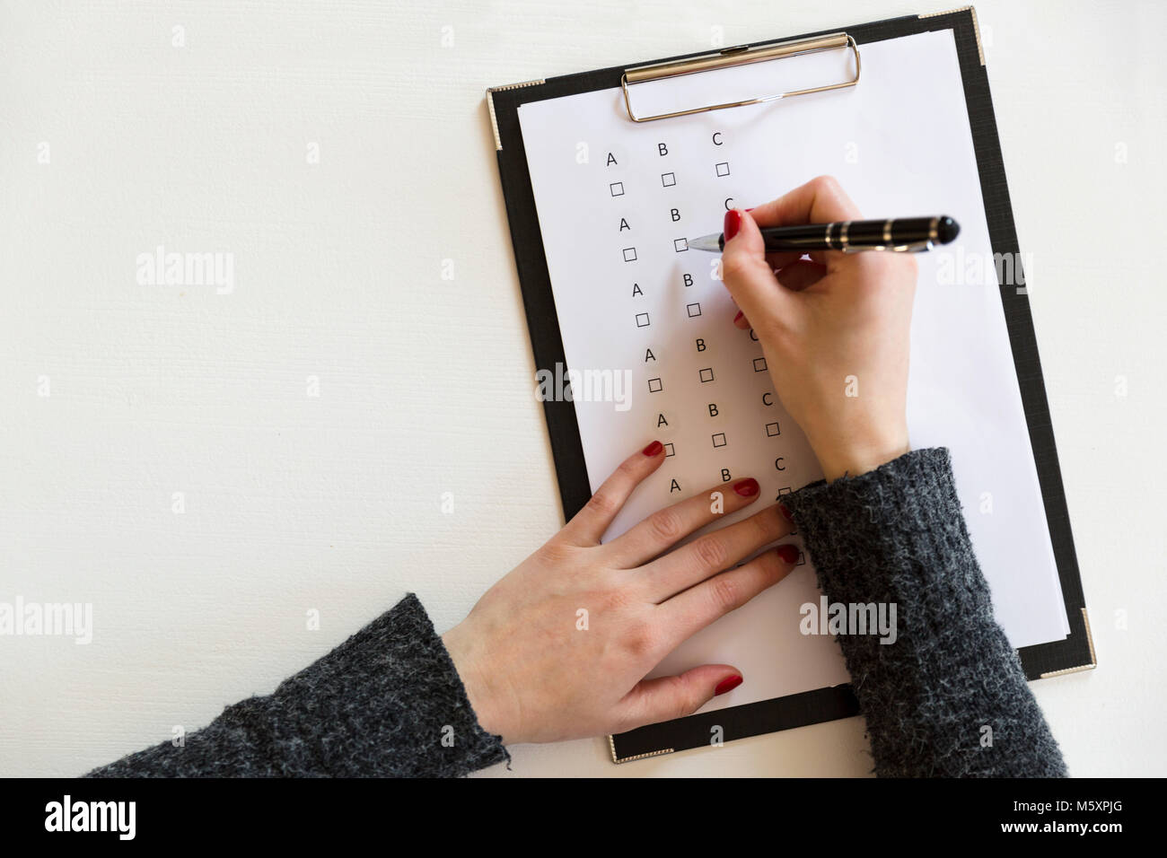 Hand with pen over questionnaire application form Stock Photo - Alamy