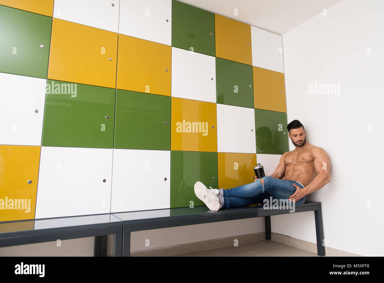 Young Man Resting In Gym Dressing Room With Supplements Shaker for Copy ...