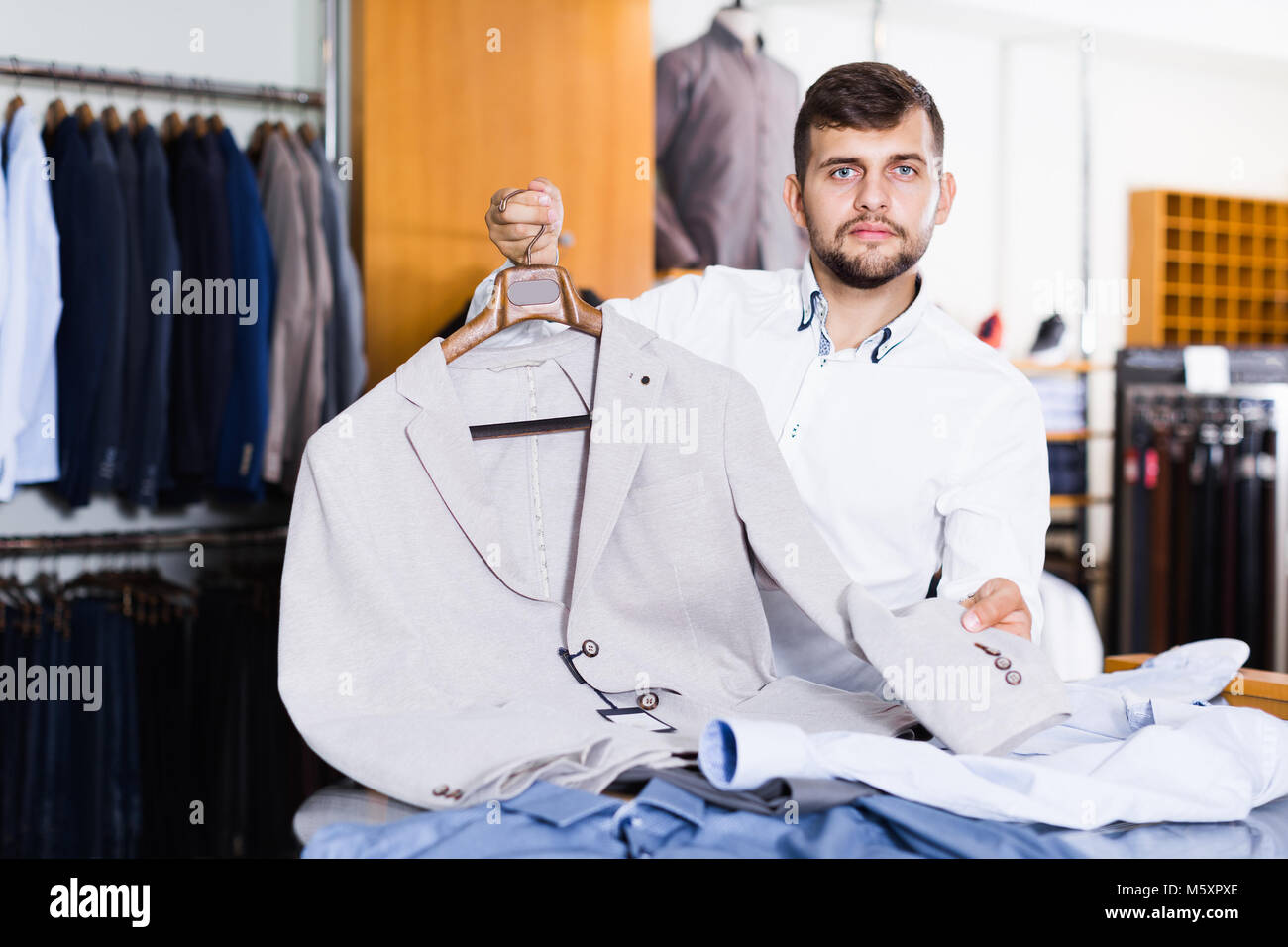 Adult salesman demonstration classic jacket in men boutique Stock Photo ...