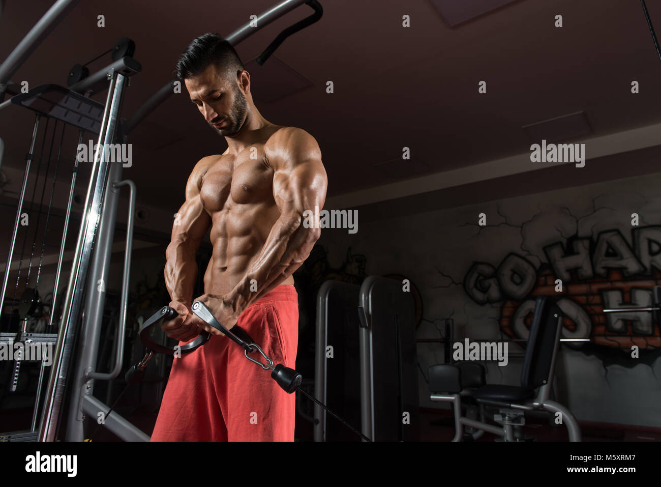 Muscular Man Doing Heavy Weight Exercise For Chest On Machine With ...