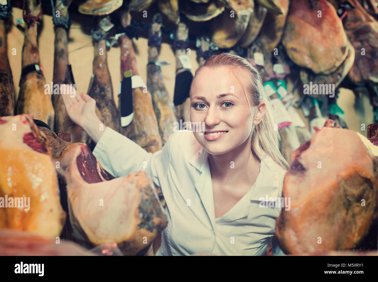 Friendly smiling young female seller wearing uniform working with ...