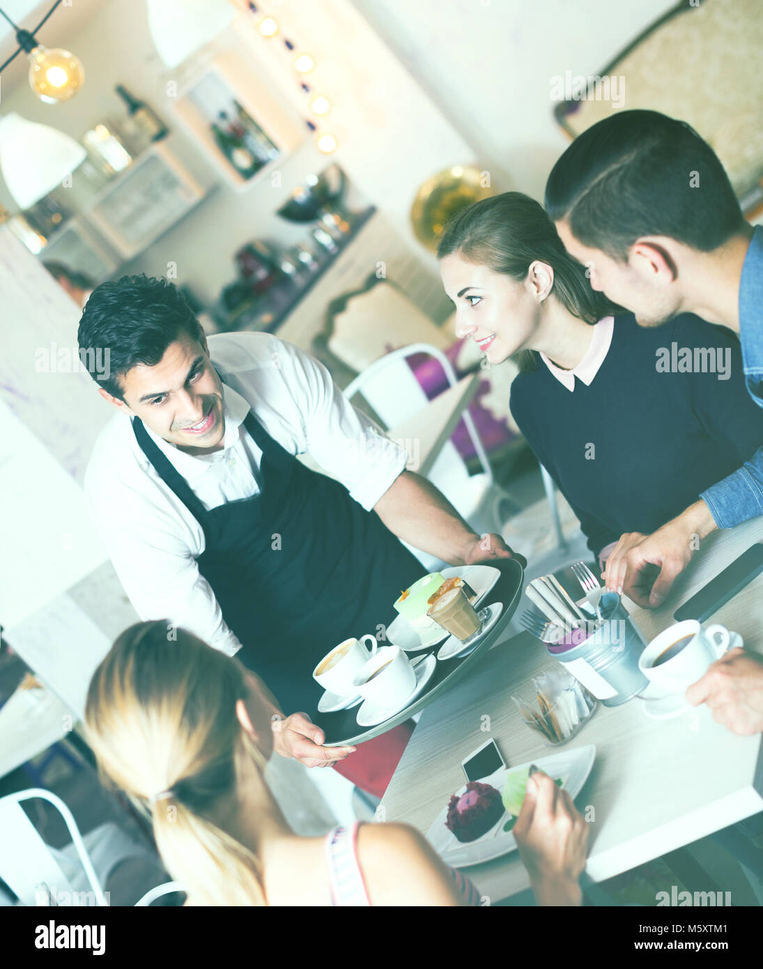Man is bringing drinking and delicious desserts to clients of cafe ...