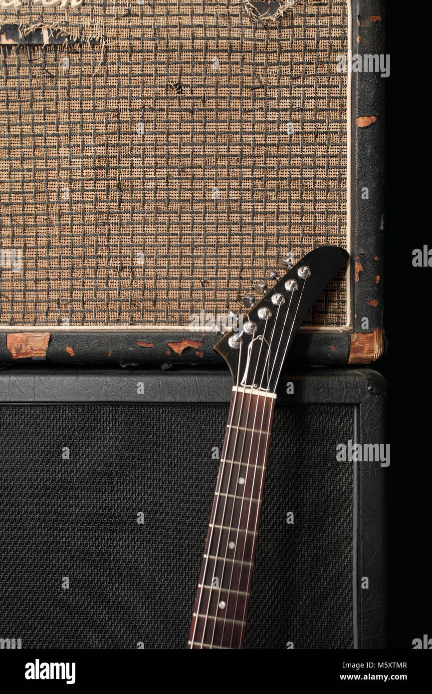Photo of an electric guitar leaning up against an old vintage guitar ...