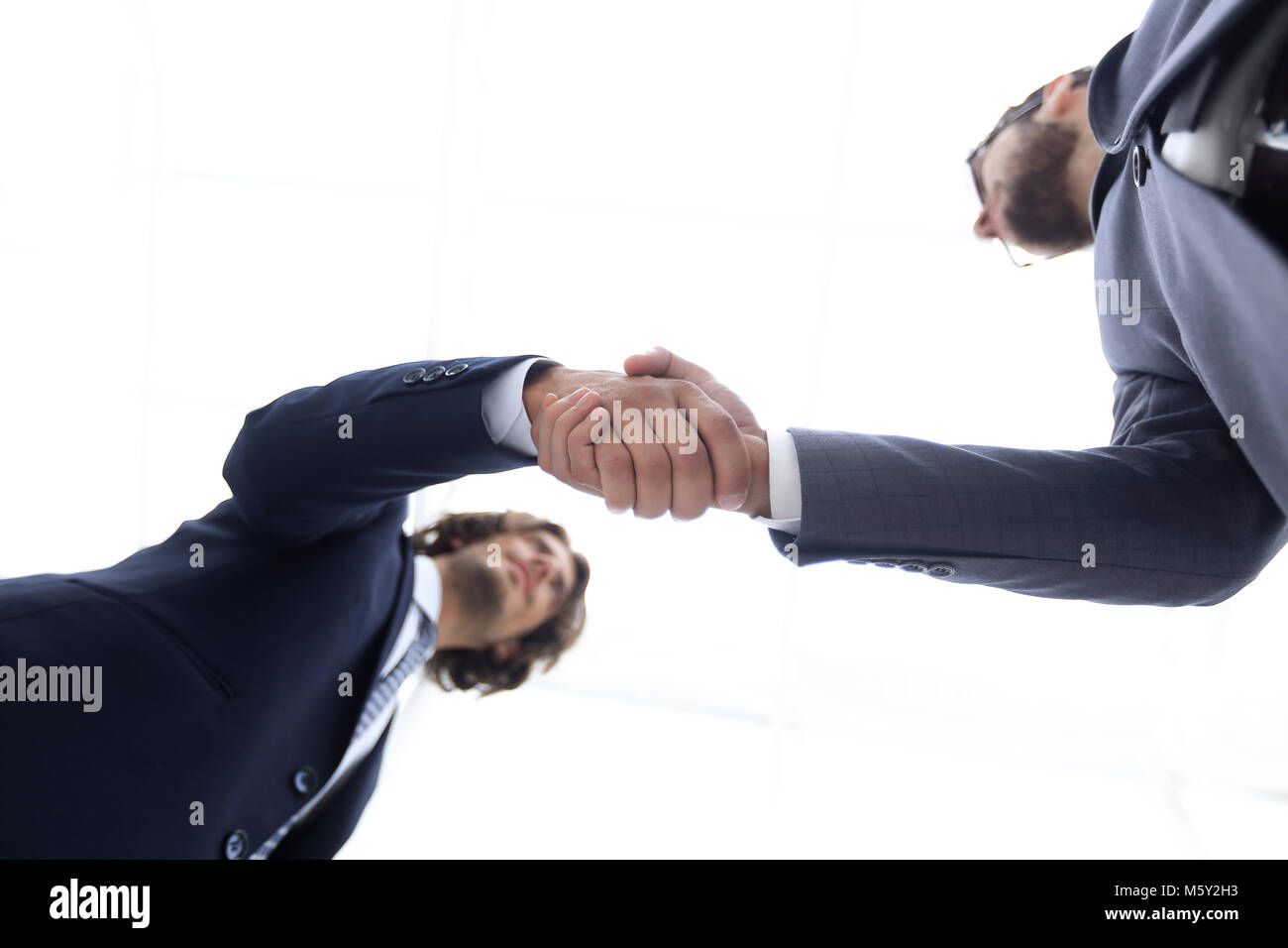 bottom view of two men shaking hands while standing Stock Photo - Alamy