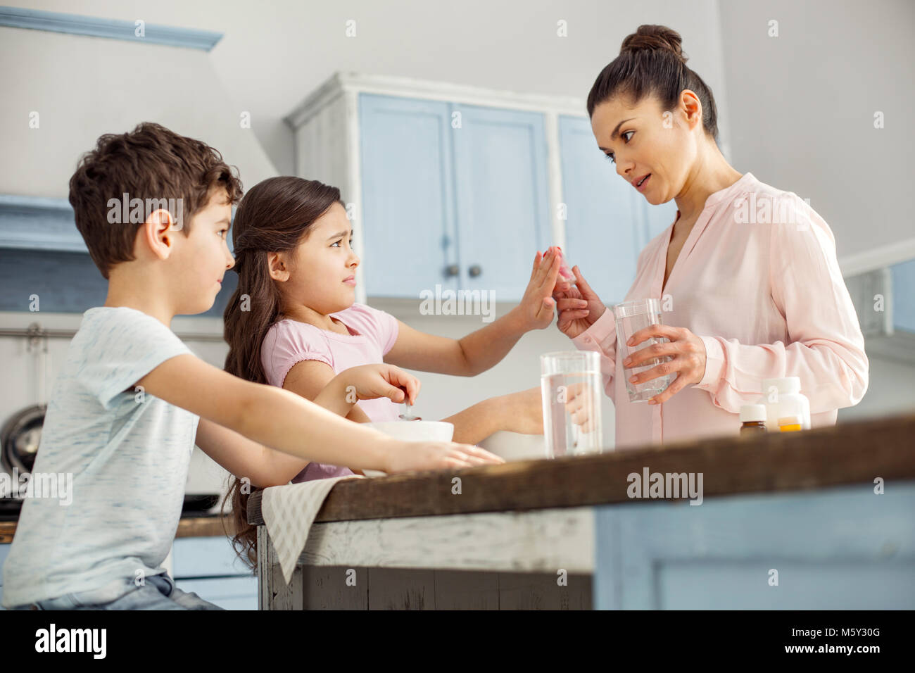 Poor little girl refusing taking vitamins Stock Photo - Alamy