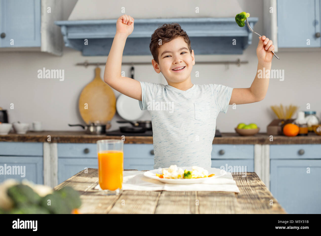 Joyful healthy boy showing his muscles Stock Photo - Alamy