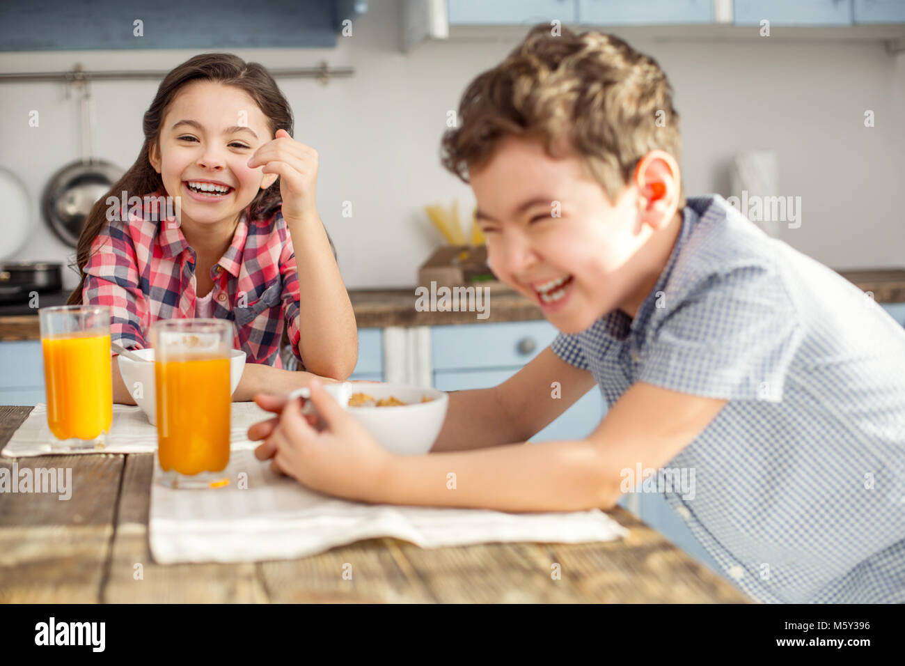 Happy little kids laughing at the table Stock Photo - Alamy