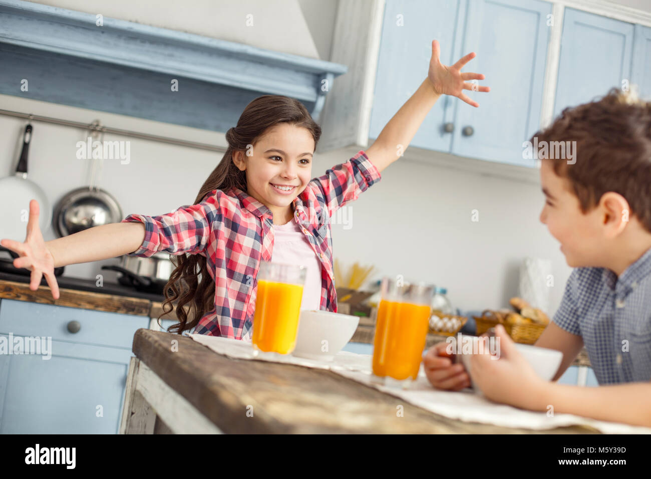 Exuberant girl telling a story to her brother Stock Photo - Alamy