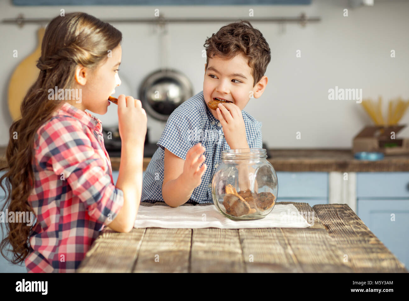 Alert children having some cookies Stock Photo - Alamy