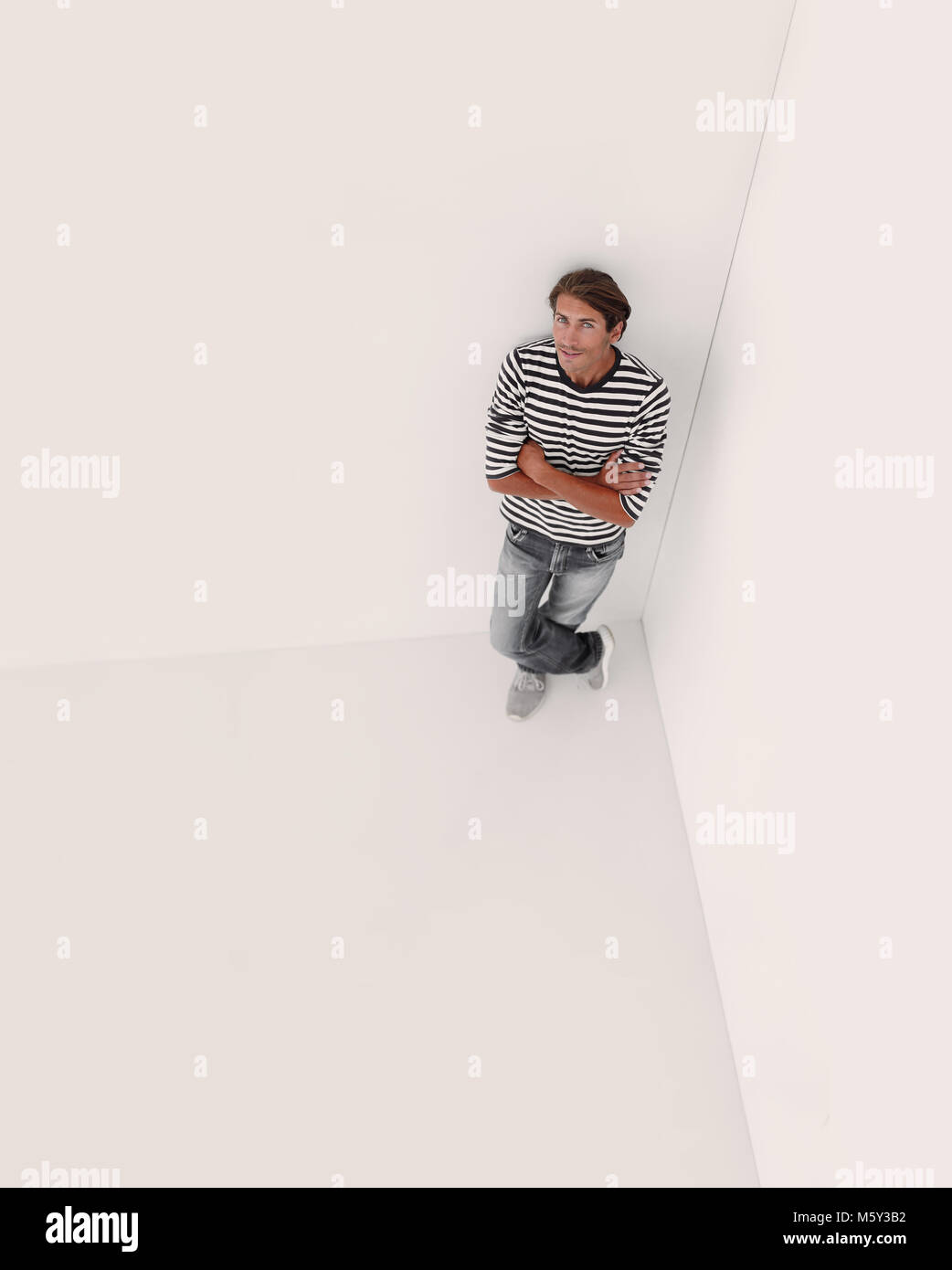 handsome guy standing near the white wall Stock Photo - Alamy