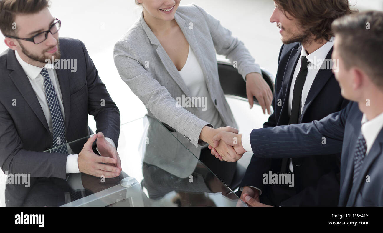 handshake business partners for their Desk Stock Photo - Alamy