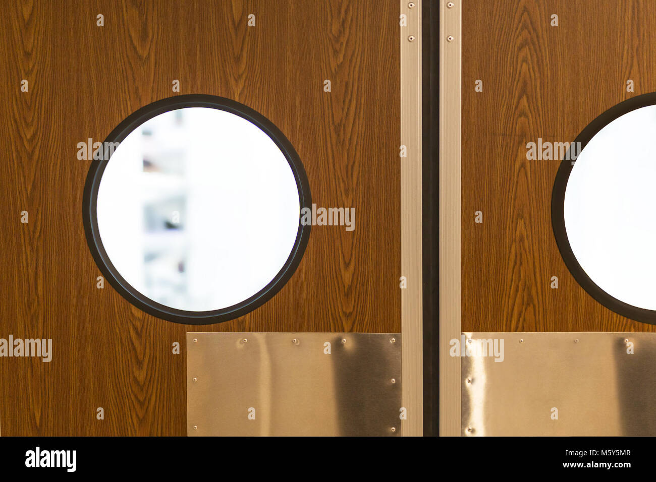 Restaurant kitchen entrance. Closed wooden double door with round ...